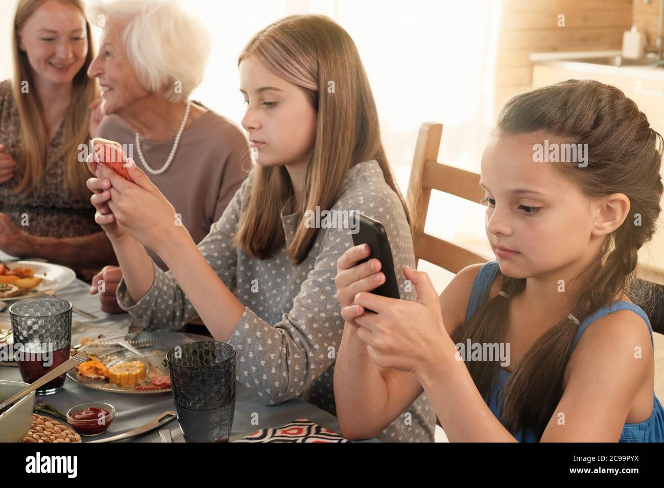 Family looking smartphones dinner table hi-res stock photography and ...