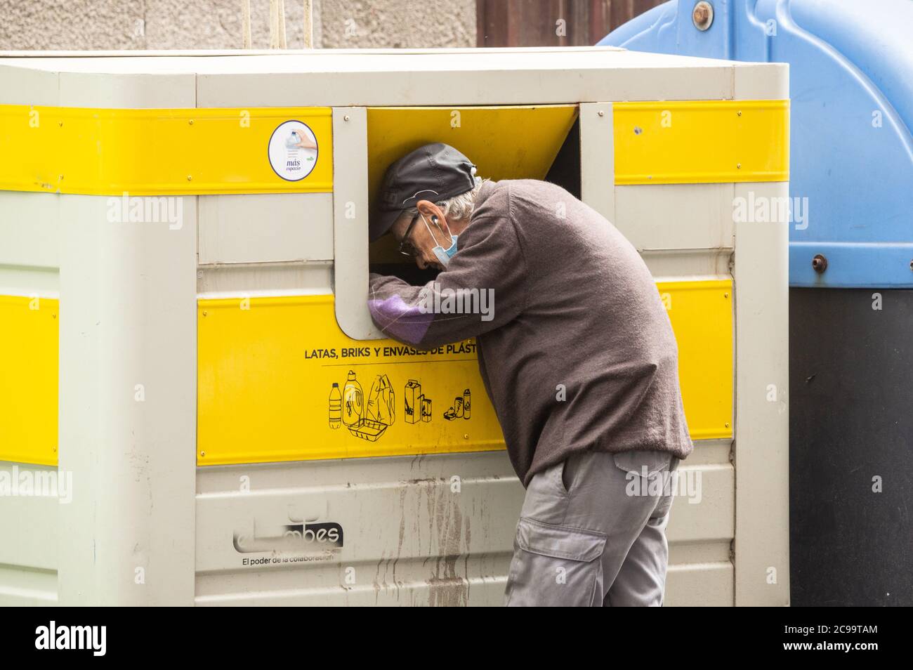 Elderly man rummaging inside rubbish container in street in Spain Stock ...