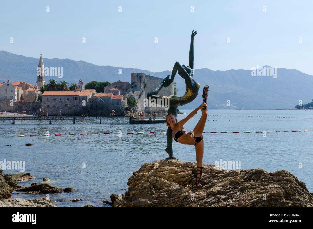 Tourist posing for a photo near statue Stock Photo - Alamy