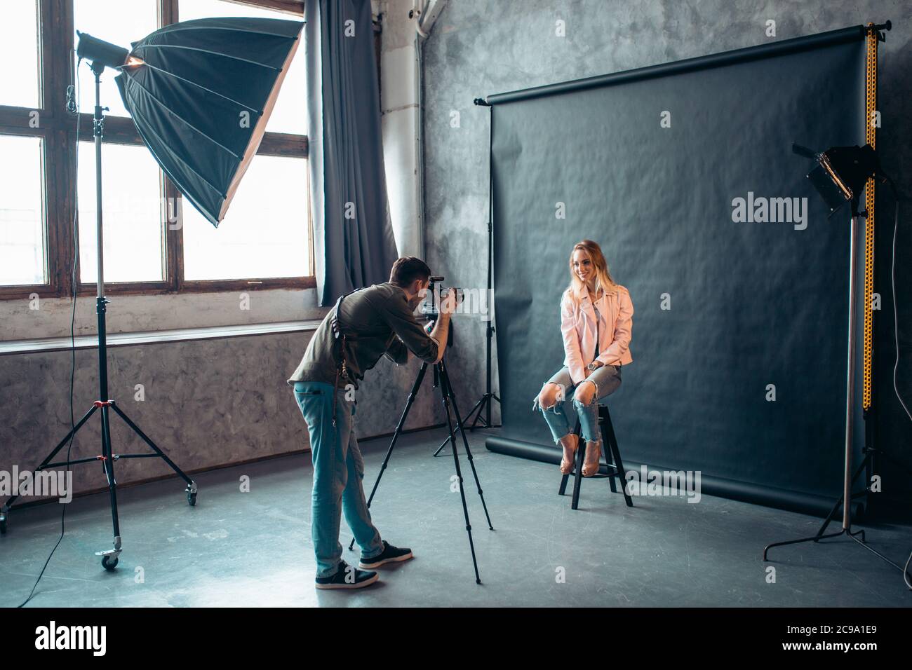 pleasant photographer making a female model laugh, side view full ...