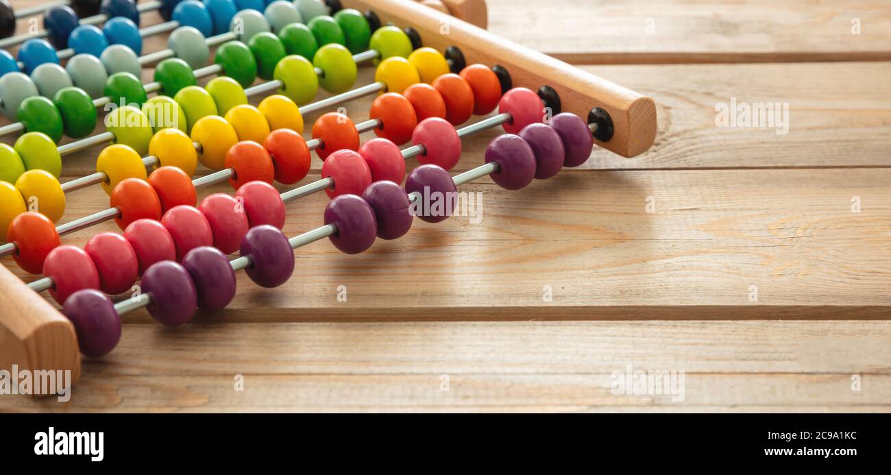 School abacus with colorful beads on wooden desk, close up view, copy ...