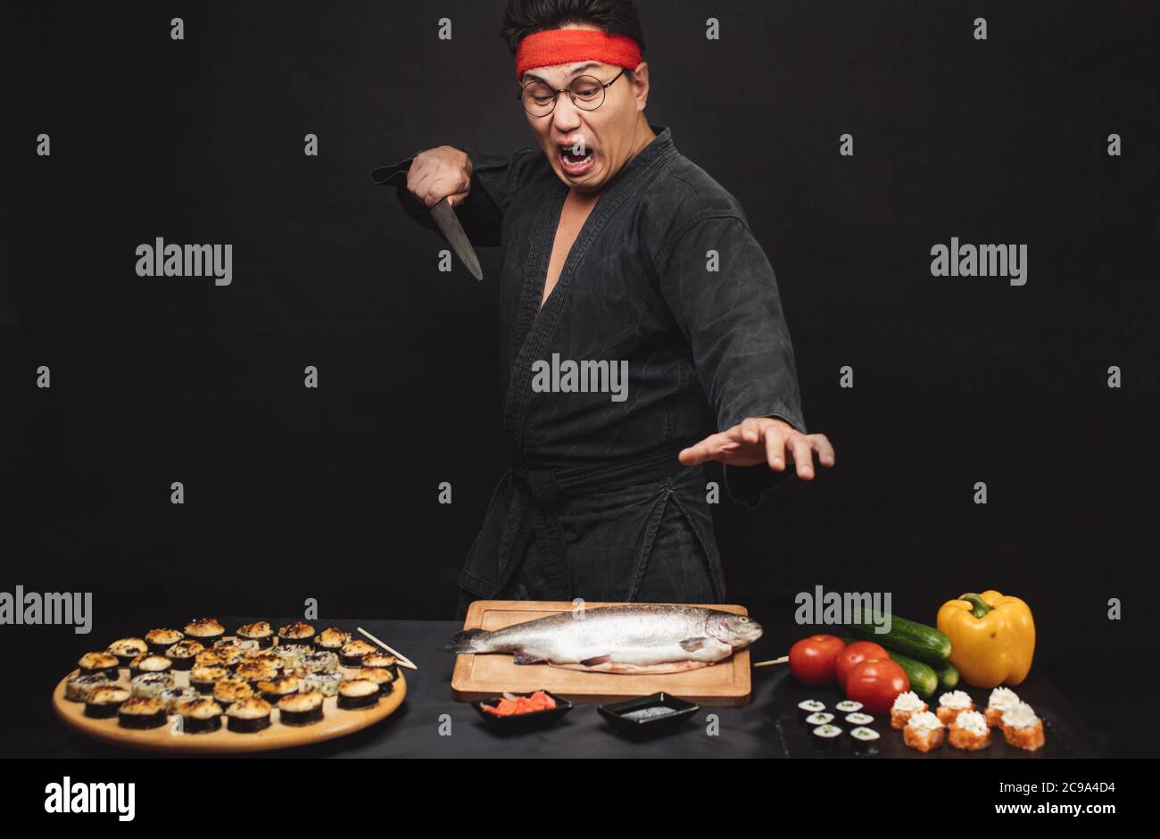 crazy furious angry chef with a knife is going to cut the fish. close ...