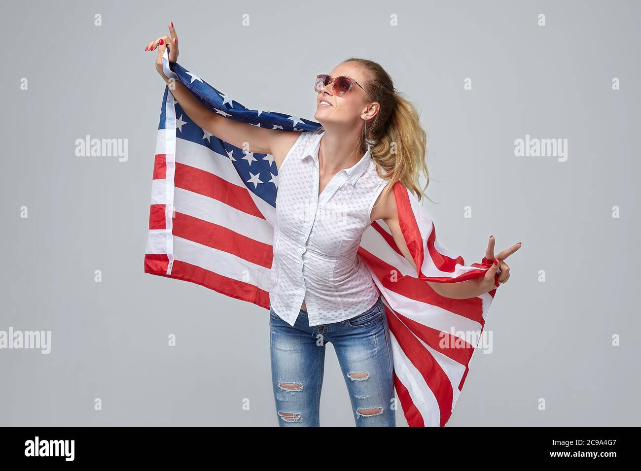 blonde woman posing with usa flag in studio on white background Stock ...