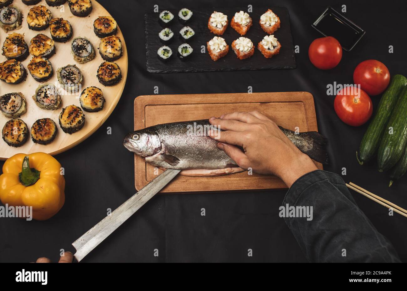 man using a knife to cut the backbone of the fish. close up top view ...