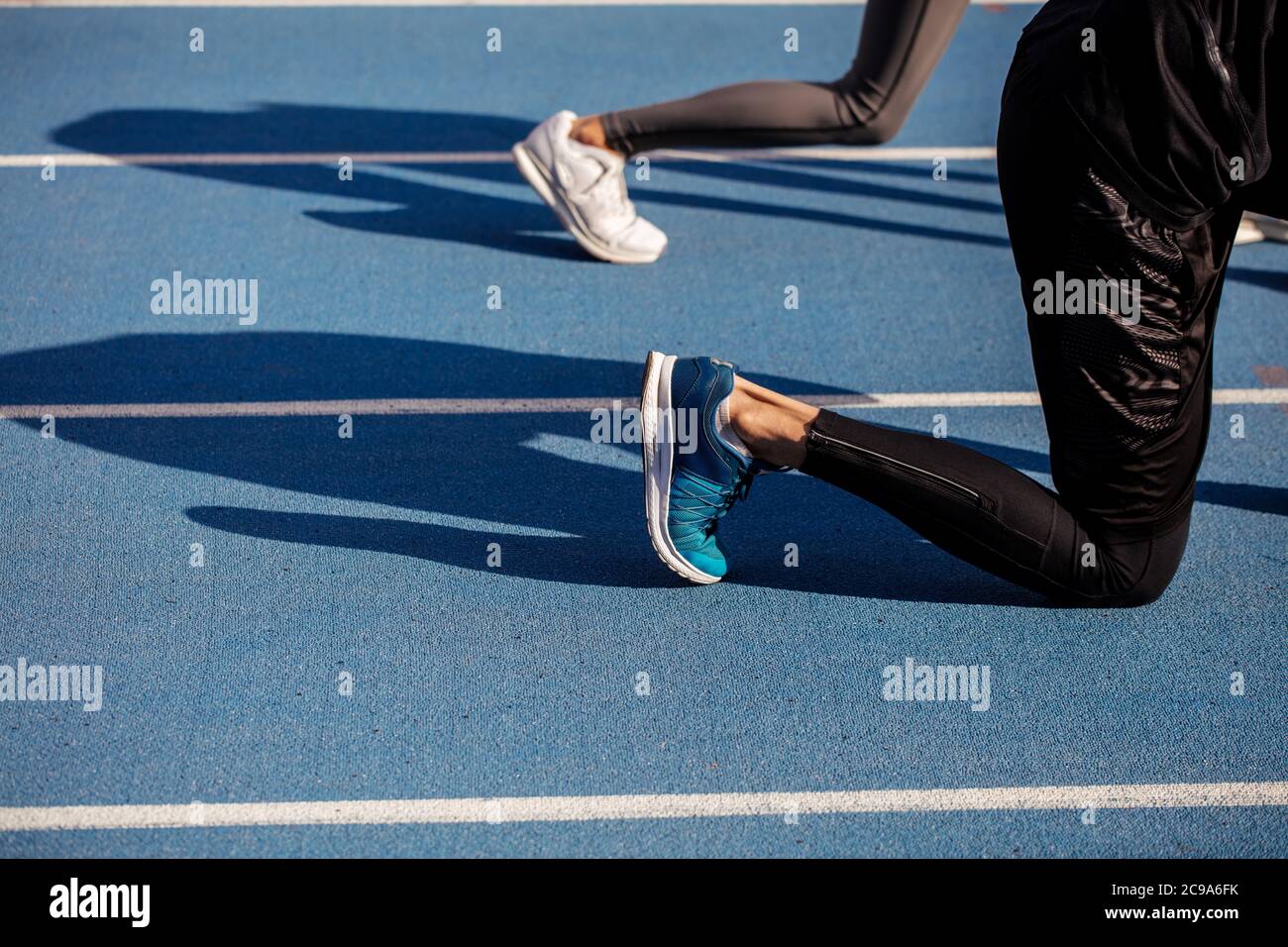 muscular runners' legs in the start position. close up side view ...