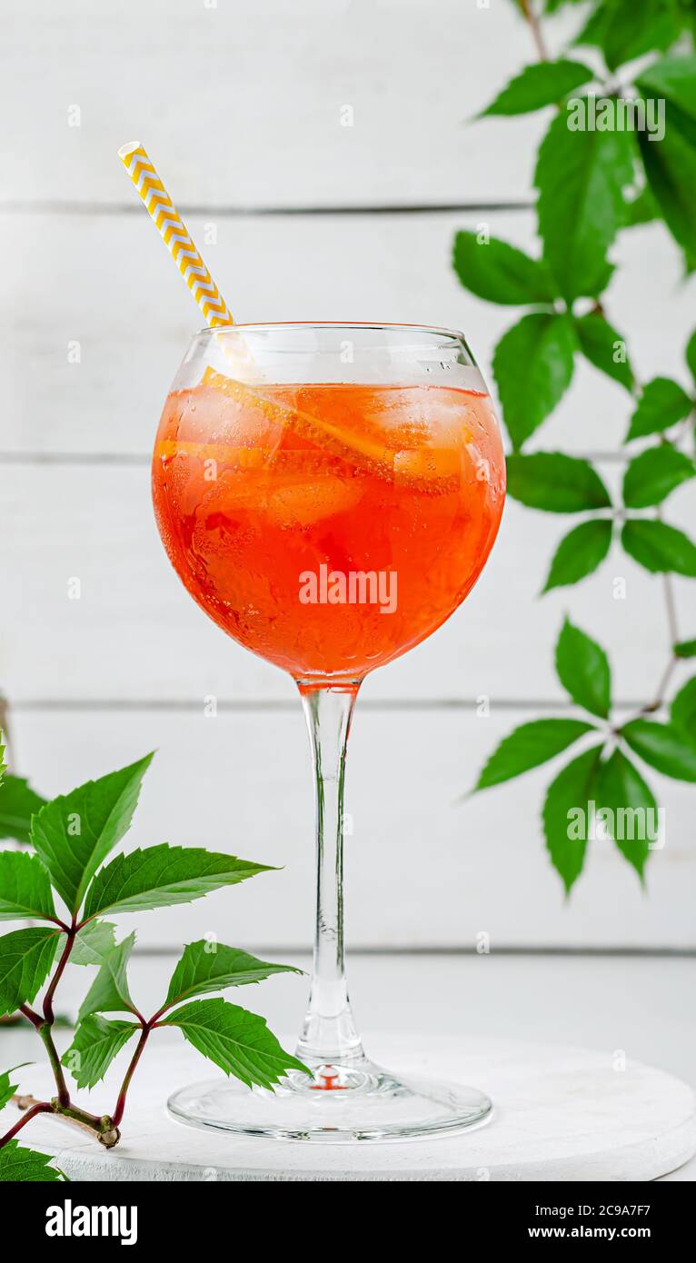 Italian aperol spritz cocktail in a wine glass on white wooden ...