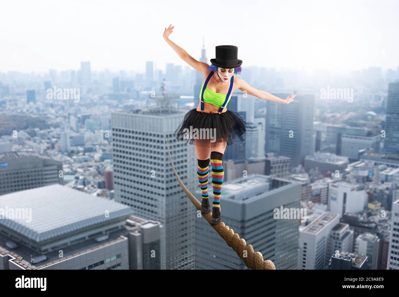 Girl clown walks on a rope over the skyscrapers of a city Stock Photo ...