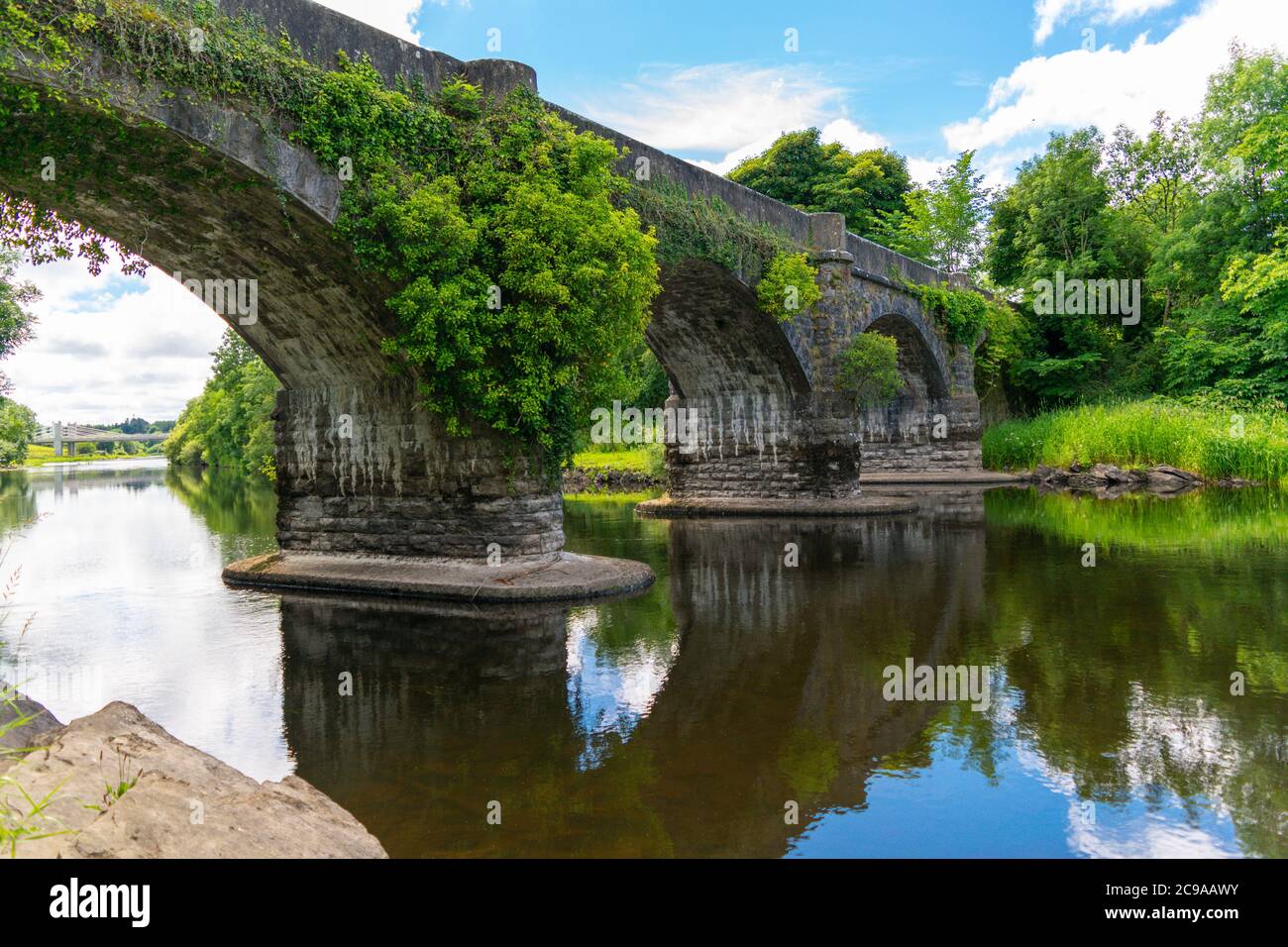 View of an old arc bridge with its reflection on the river Stock Photo ...