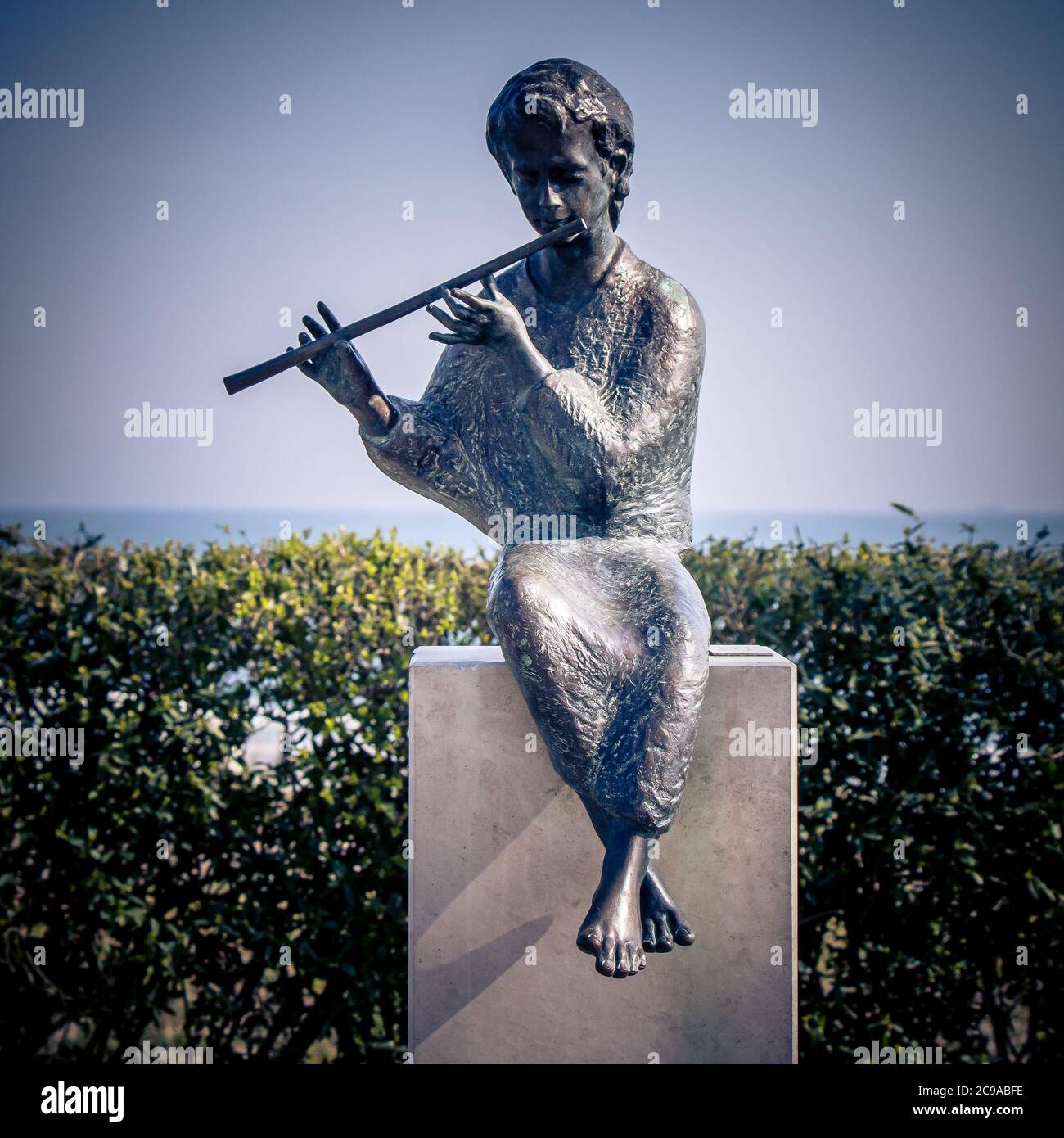 Closeup of a sculpture of a boy with a flute in the park Stock Photo ...