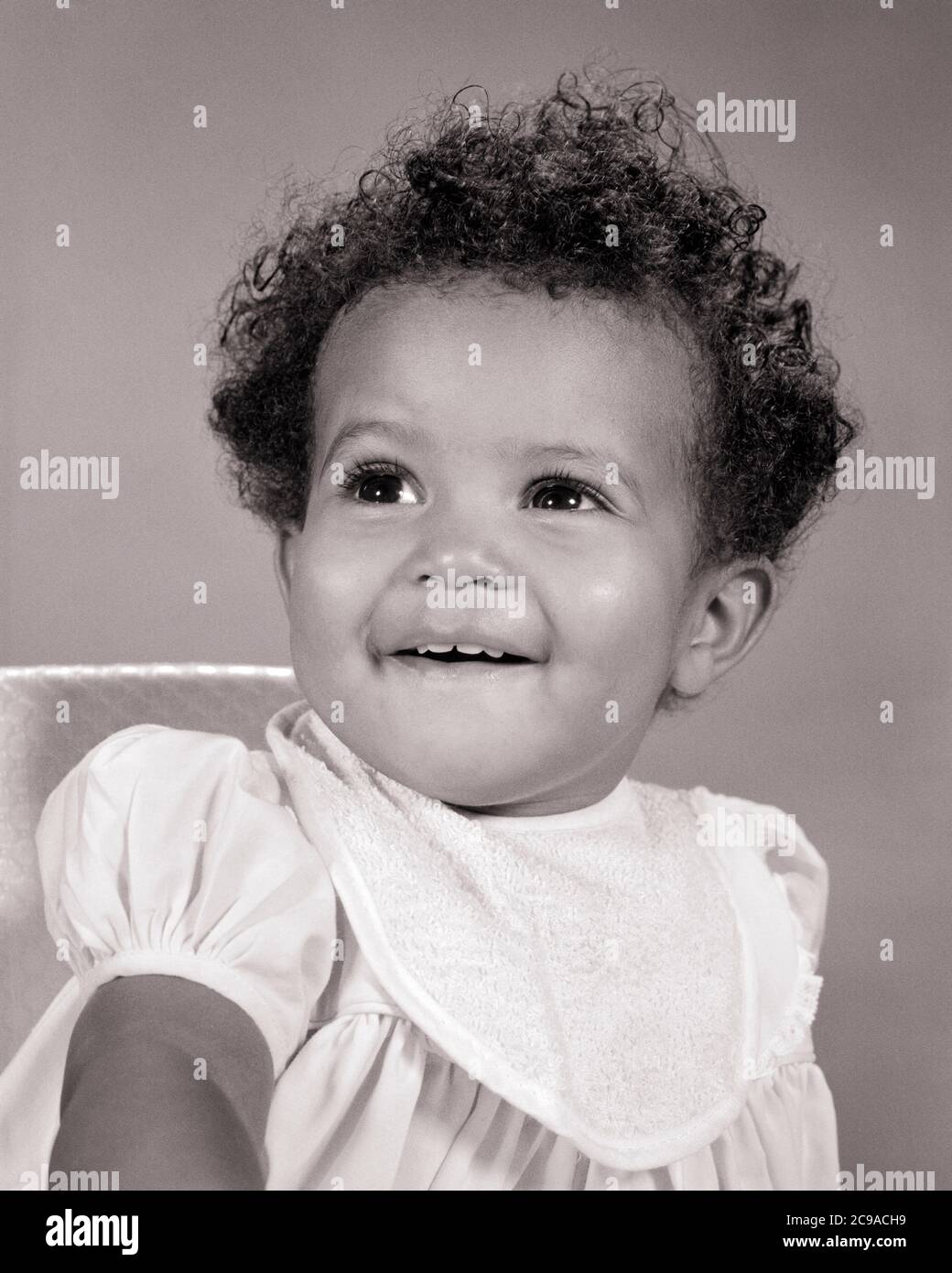 1960s ANTICIPATION SMILING HUNGRY AFRICAN-AMERICAN BABY GIRL SITTING IN ...