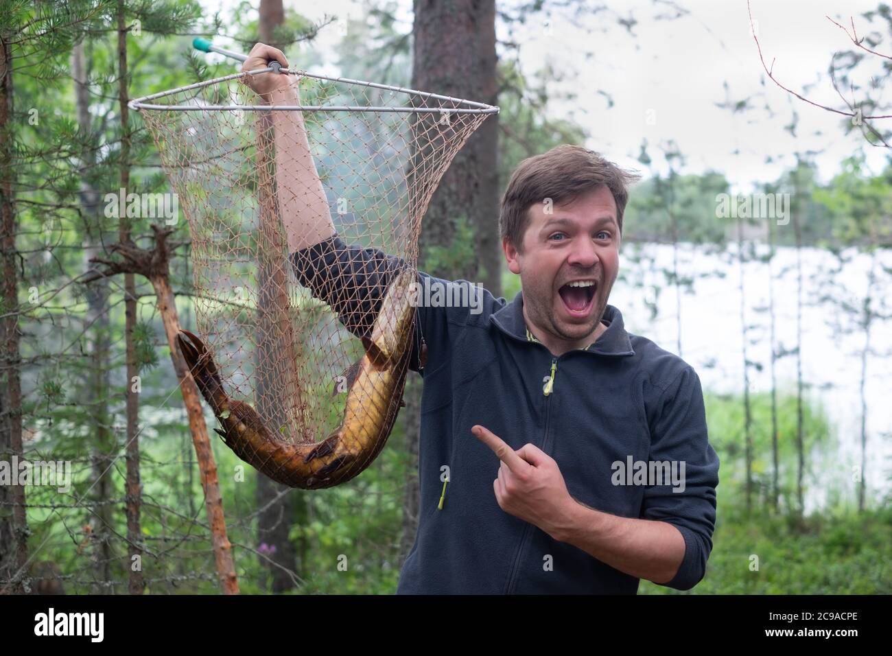 Happy caucasian fisherman showing caught trophy pike Stock Photo - Alamy