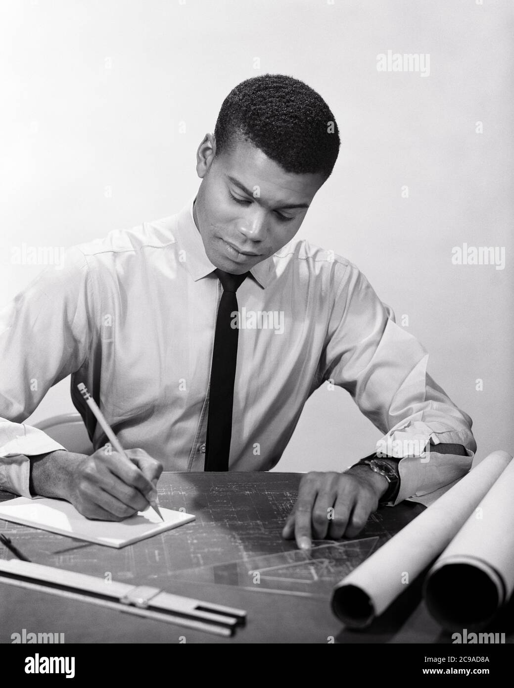 1950s 1960s SINGLE AFRICAN-AMERICAN MAN ENGINEER WORKING REVIEWING ...