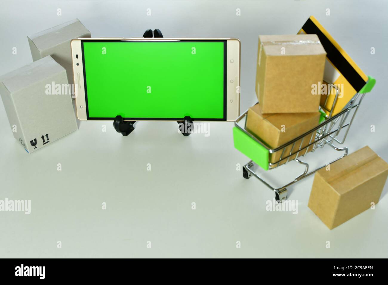 Small shopping cart with boxes and a phone with a green screen - online ...