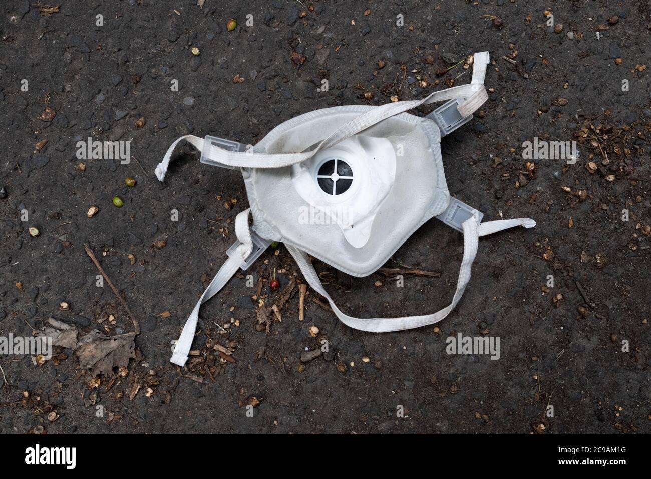 Face mask with valve discarded and dropped on road during coronavirus ...