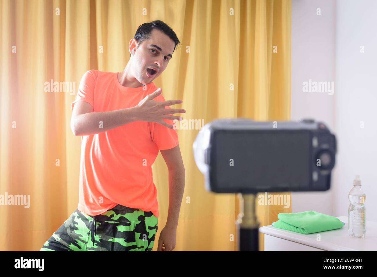 A male model exercising at home and recording the process with a camera ...