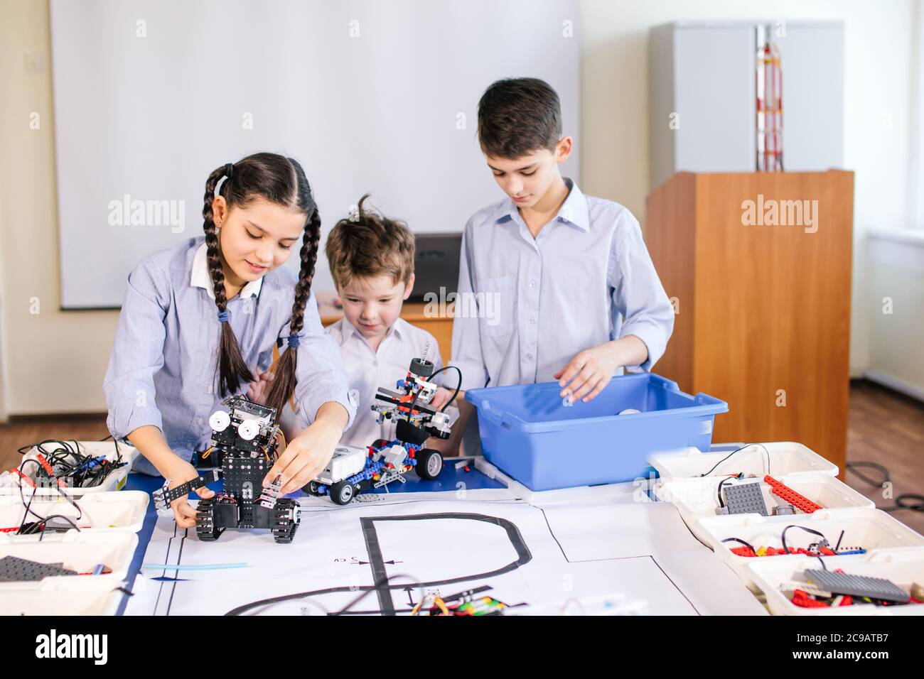 Happy little inventor kids fit the separate component parts of ...