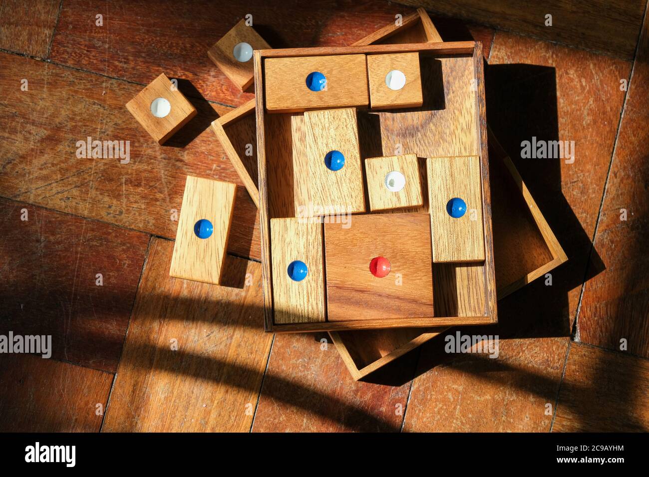 Wooden tray puzzle sitting in a patch of sunlight on a worn wooden ...