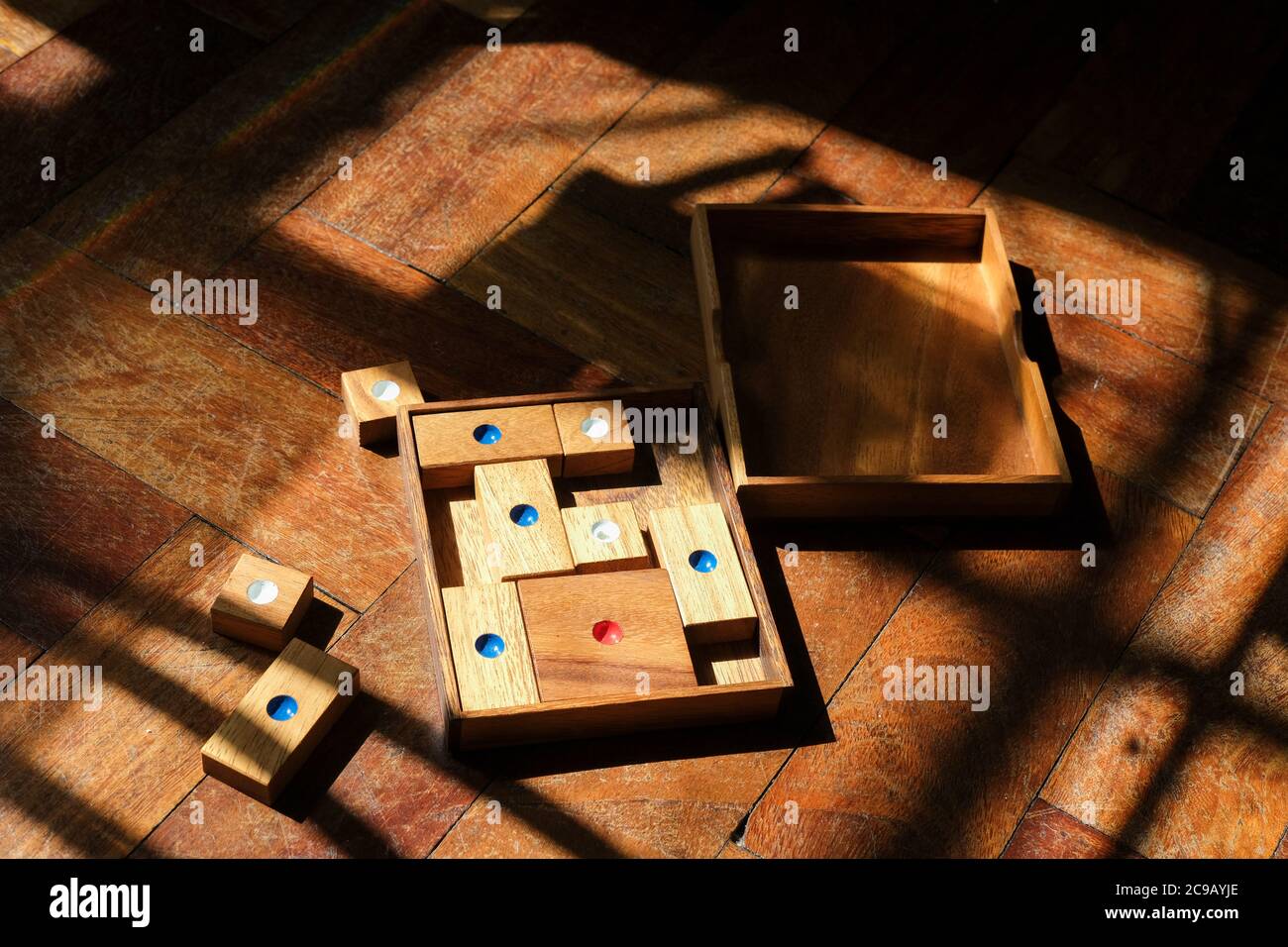 Wooden tray puzzle sitting in a patch of sunlight on a worn wooden ...