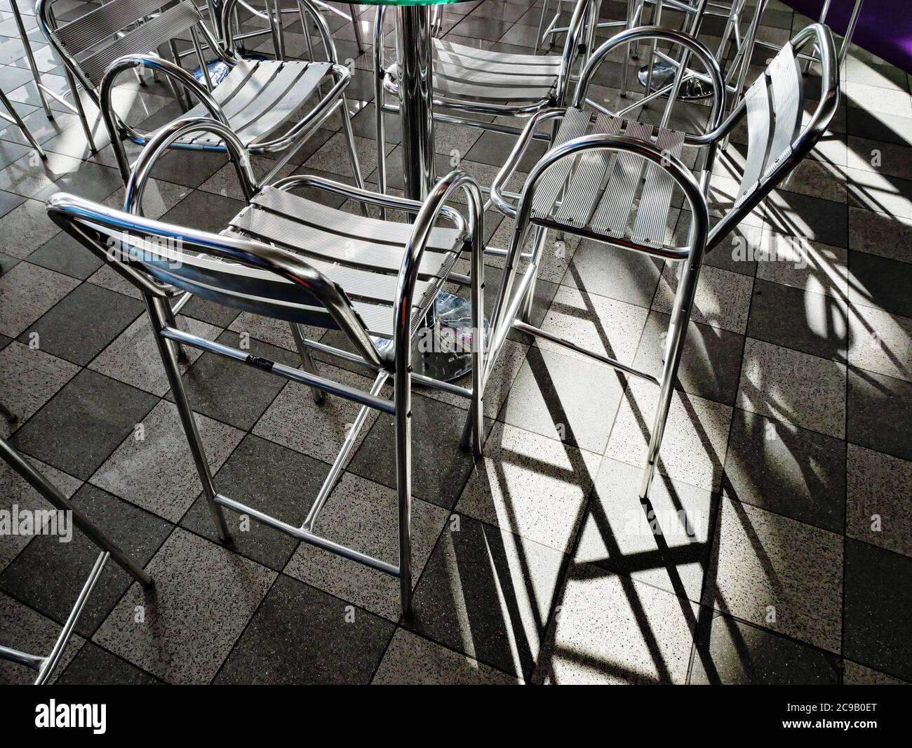 Aluminium chairs and table on a tiled floor in a fast food restaurant ...