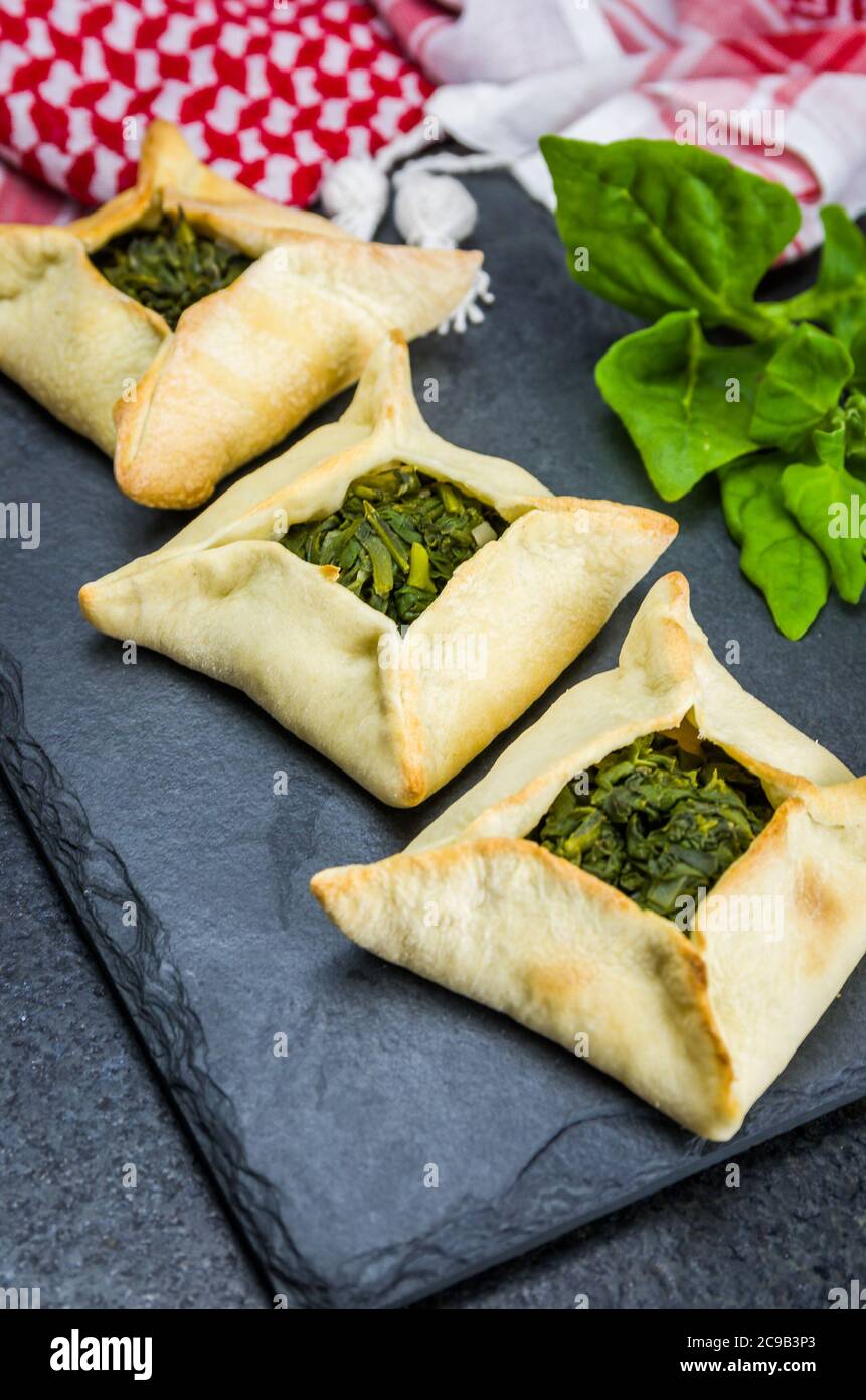 Delicious Lebanese (Arabic) food, spinach sfiha on black slate stone ...