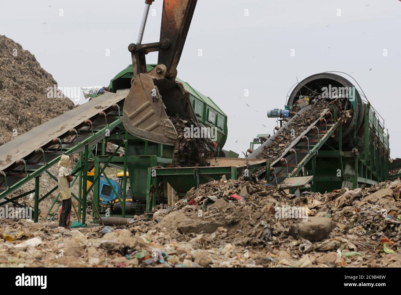 East Delhi Municipal Corporation (EDMC) workers load garbage in a ...