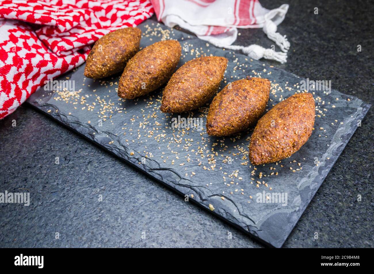 Delicious Lebanese (Arabic) food, kibbeh (kibe) on black slate stone ...