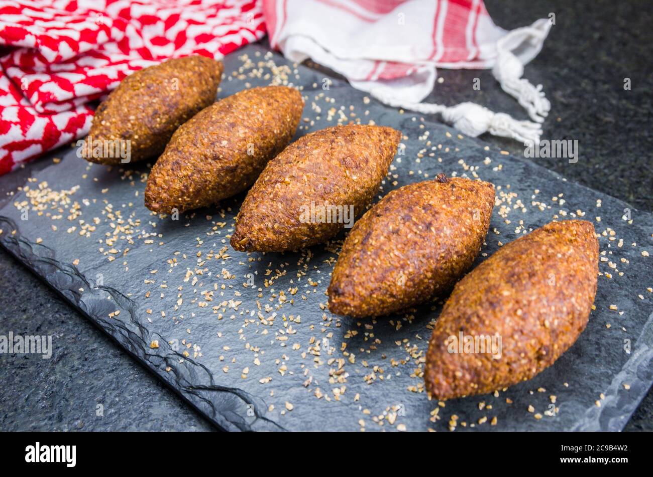 Delicious Lebanese (Arabic) food, kibbeh (kibe) on black slate stone ...