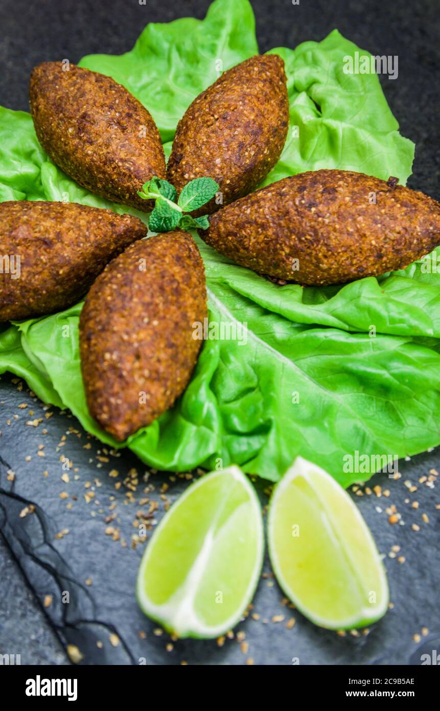 Delicious Lebanese (Arabic) food, kibbeh (kibe) on black slate stone ...