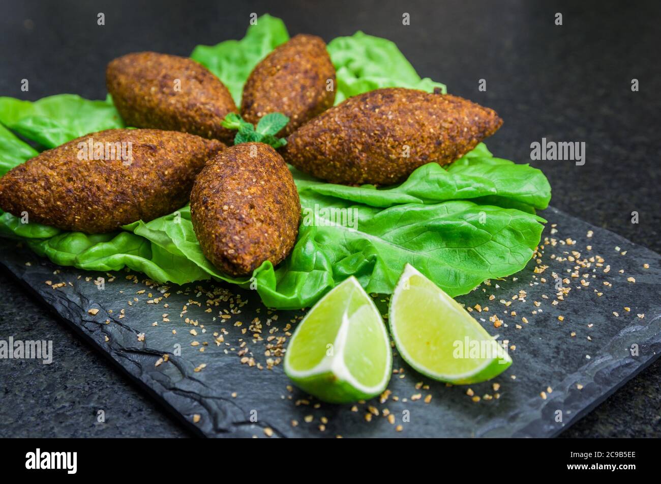 Delicious Lebanese (Arabic) food, kibbeh (kibe) on black slate stone ...
