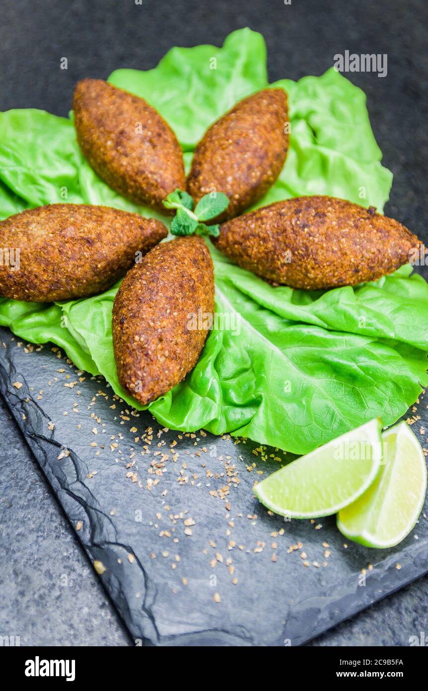 Delicious Lebanese (Arabic) food, kibbeh (kibe) on black slate stone ...