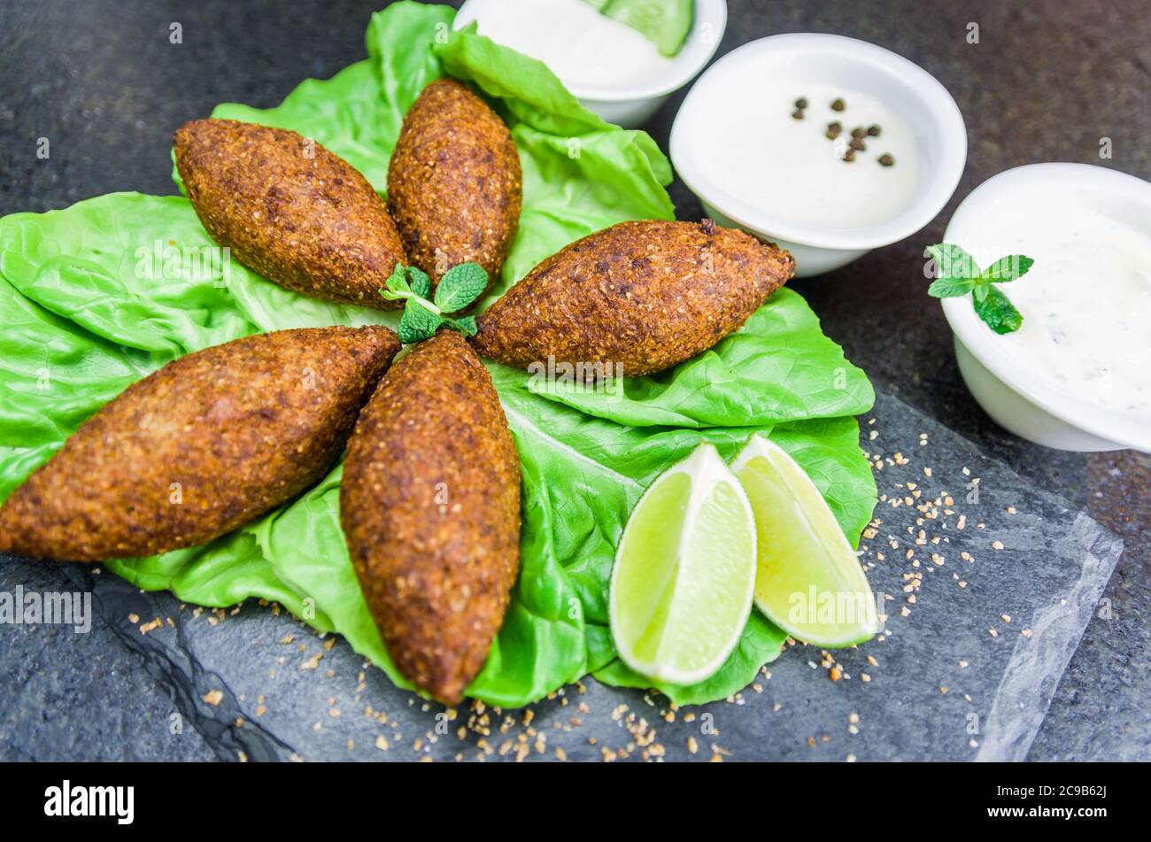 Delicious Lebanese (Arabic) food, kibbeh (kibe) on black slate stone ...
