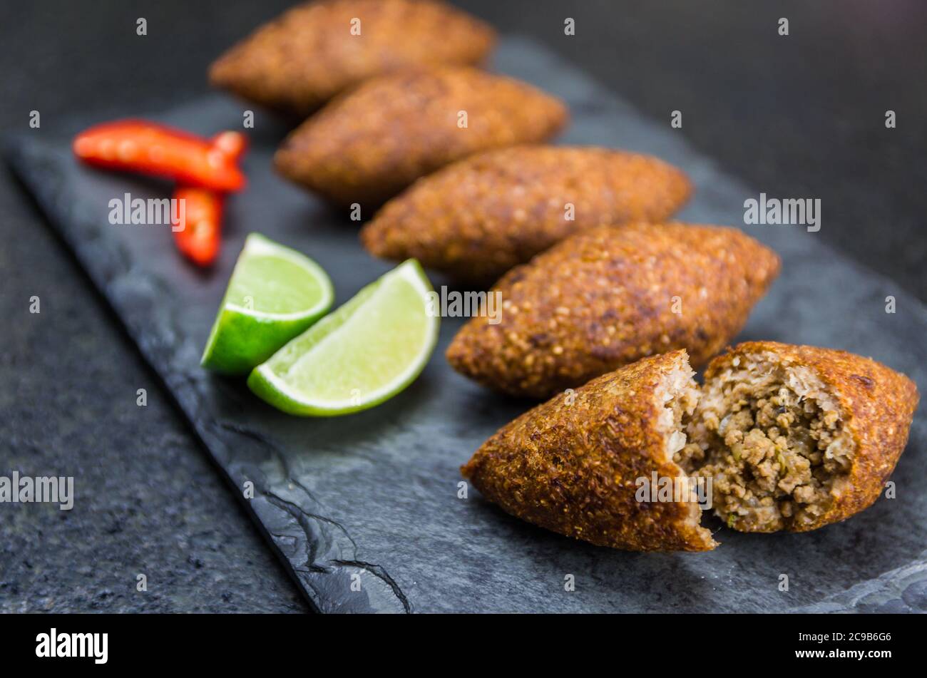 Delicious Lebanese (Arabic) food, kibbeh (kibe) on black slate stone ...