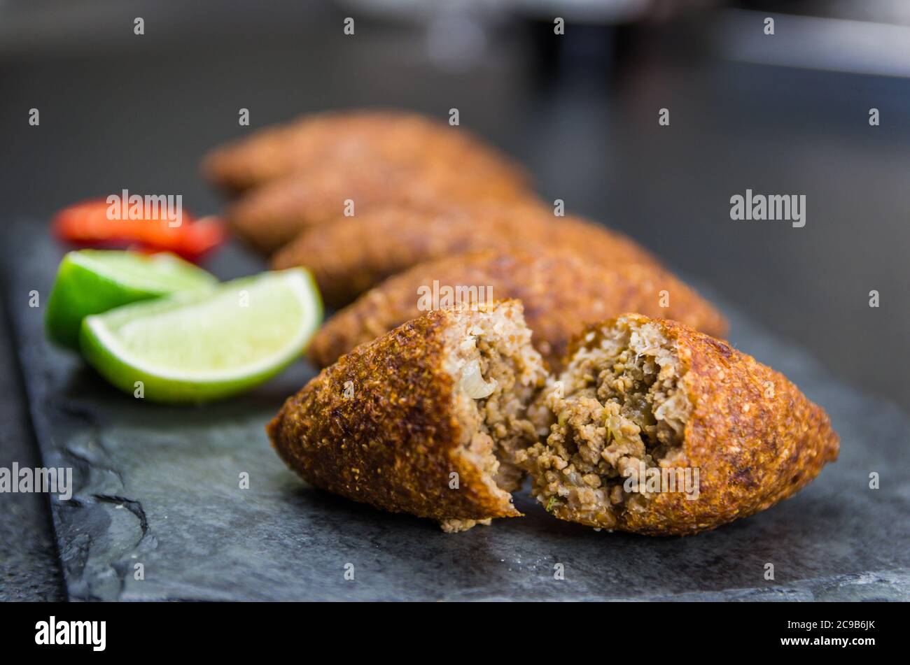 Delicious Lebanese (Arabic) food, kibbeh (kibe) on black slate stone ...