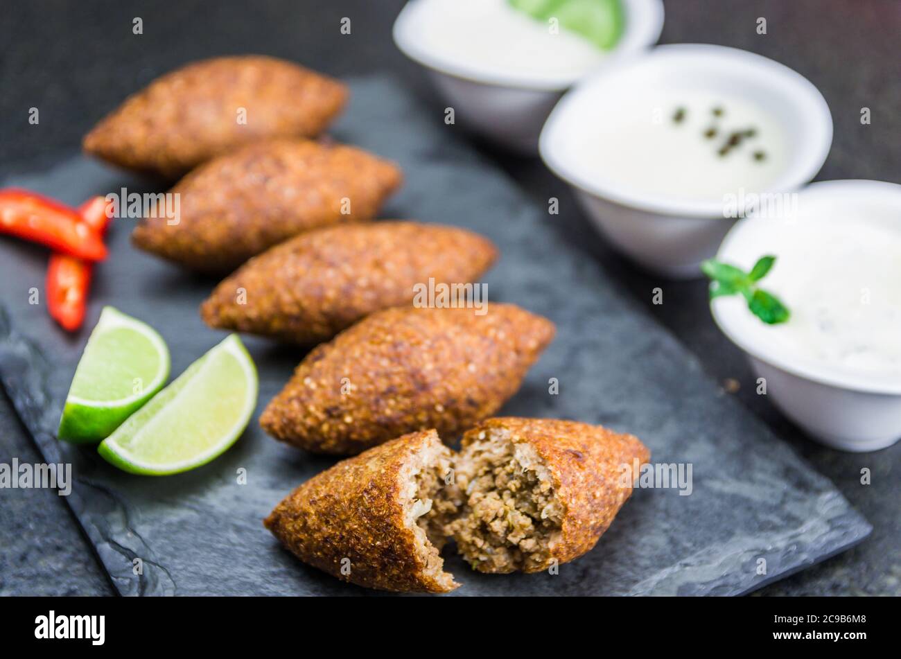 Delicious Lebanese (Arabic) food, kibbeh (kibe) on black slate stone ...