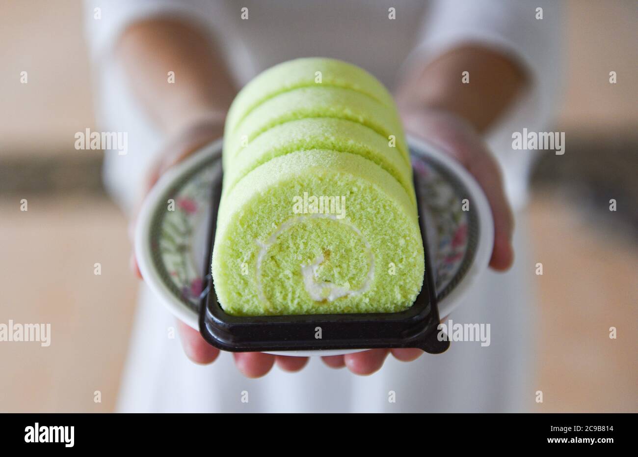 cake roll on plate / woman served green cake roll pandan with cream ...