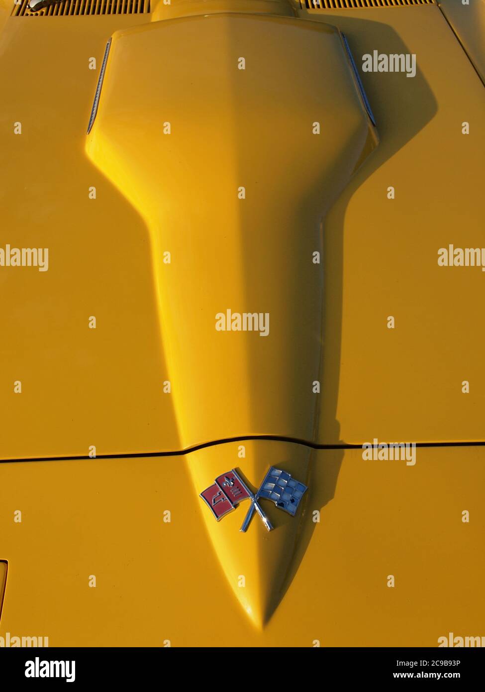 Yellow 1966 Corvette detail with crossed flags hood emblem. The large ...