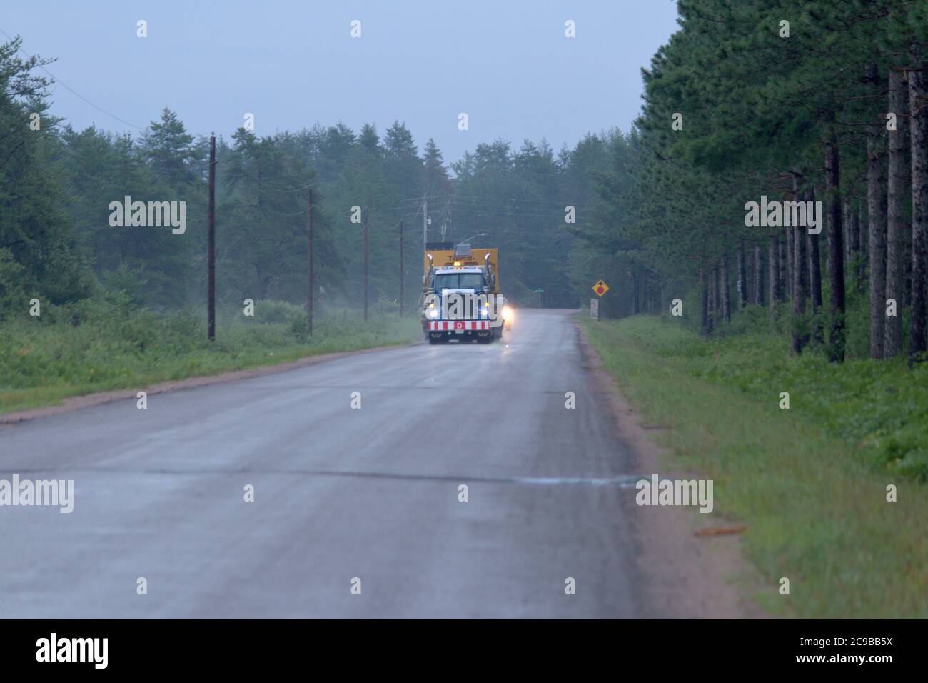 transport carrying a backhoe driving down the road Stock Photo - Alamy