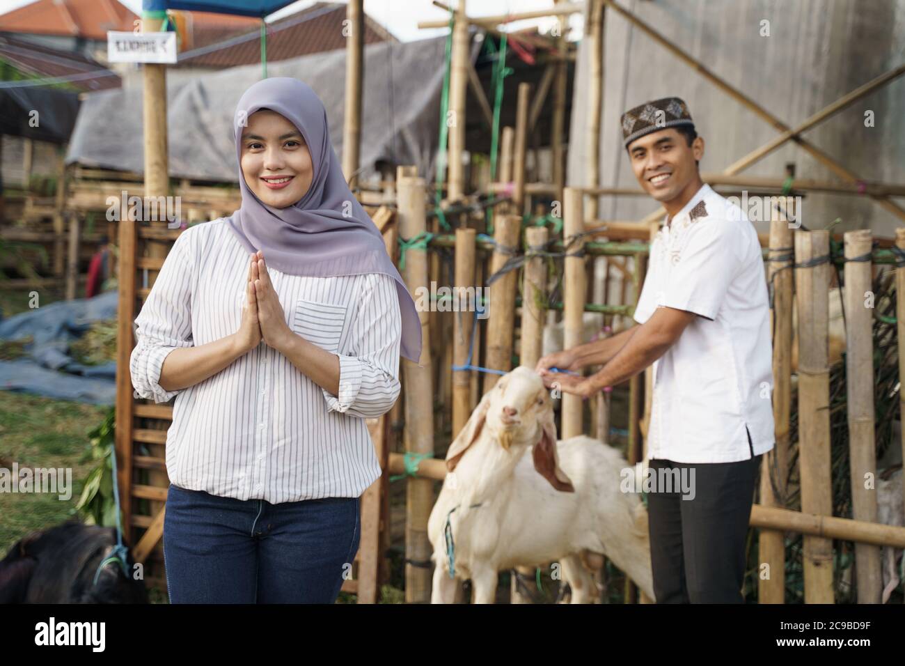 portrait of young muslim woman with goat for idul adha qurban sacrifice ...