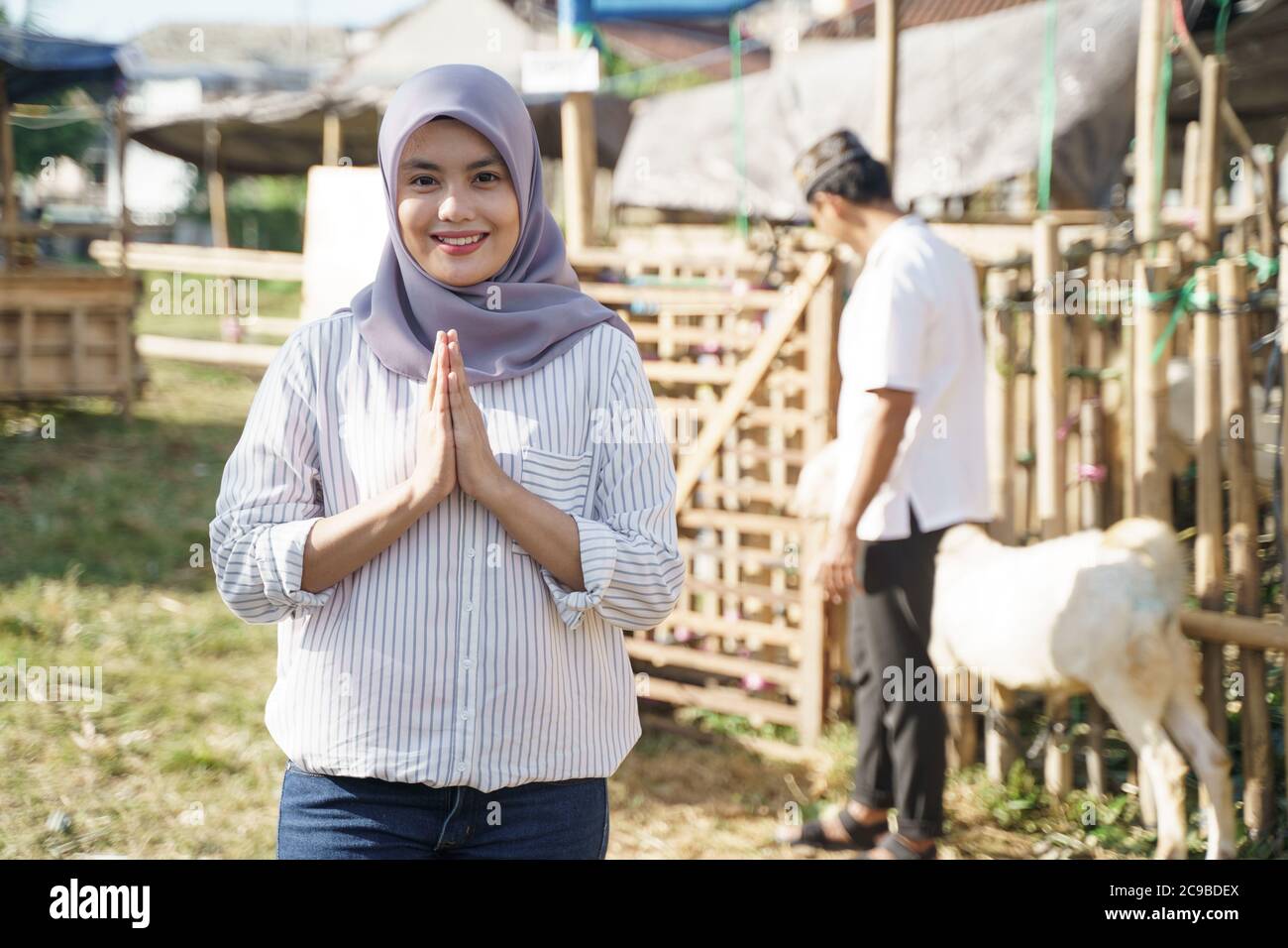 portrait of young muslim woman with goat for idul adha qurban sacrifice ...