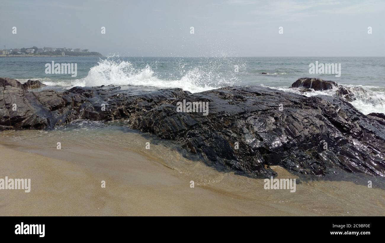 Surf waves running in the coastal rocks at the beach Stock Photo - Alamy