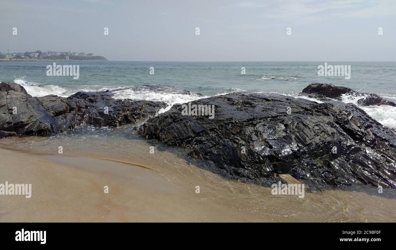 Surf waves running in the coastal rocks at the beach Stock Photo - Alamy