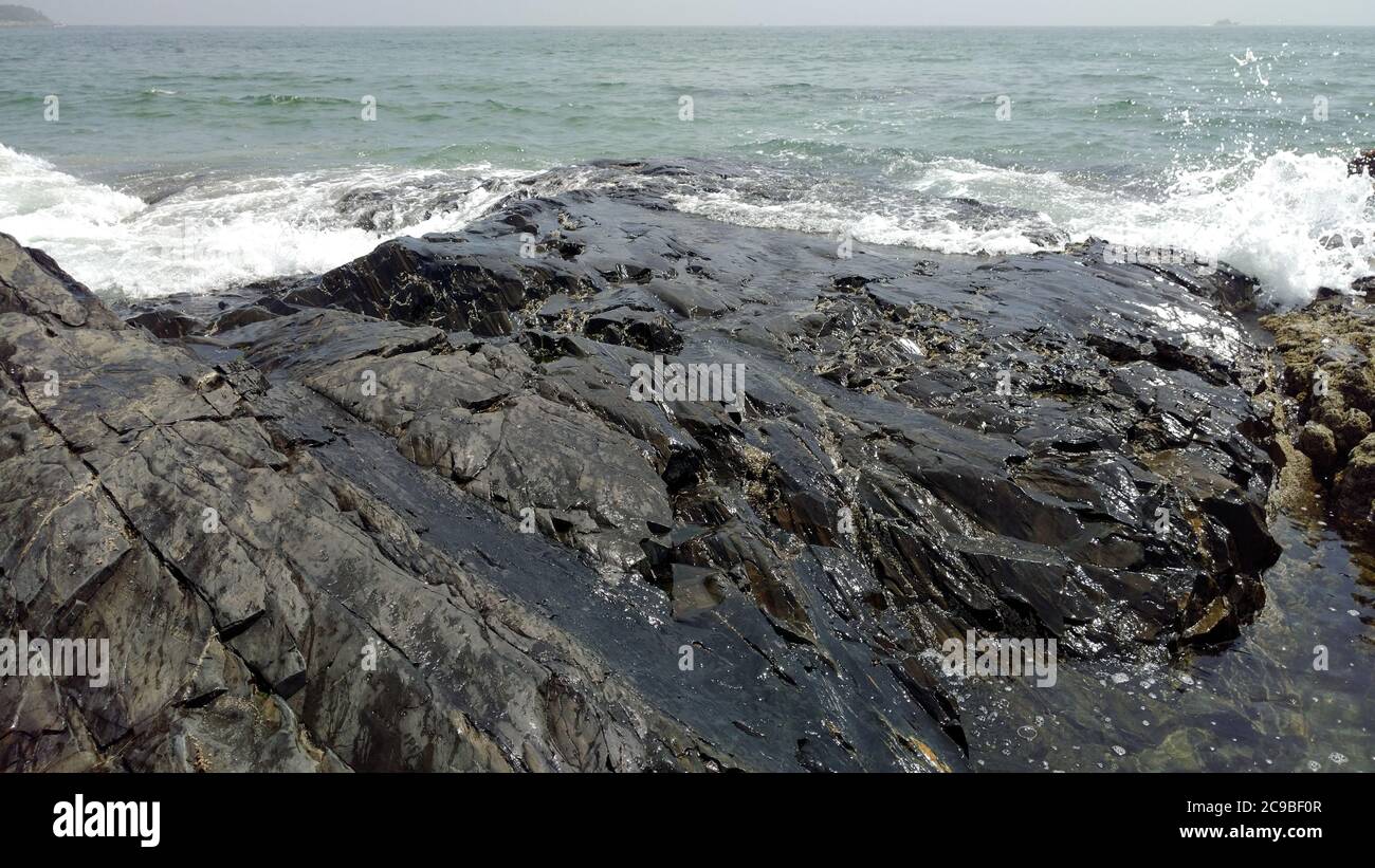 Surf waves running in the coastal rocks at the beach Stock Photo - Alamy