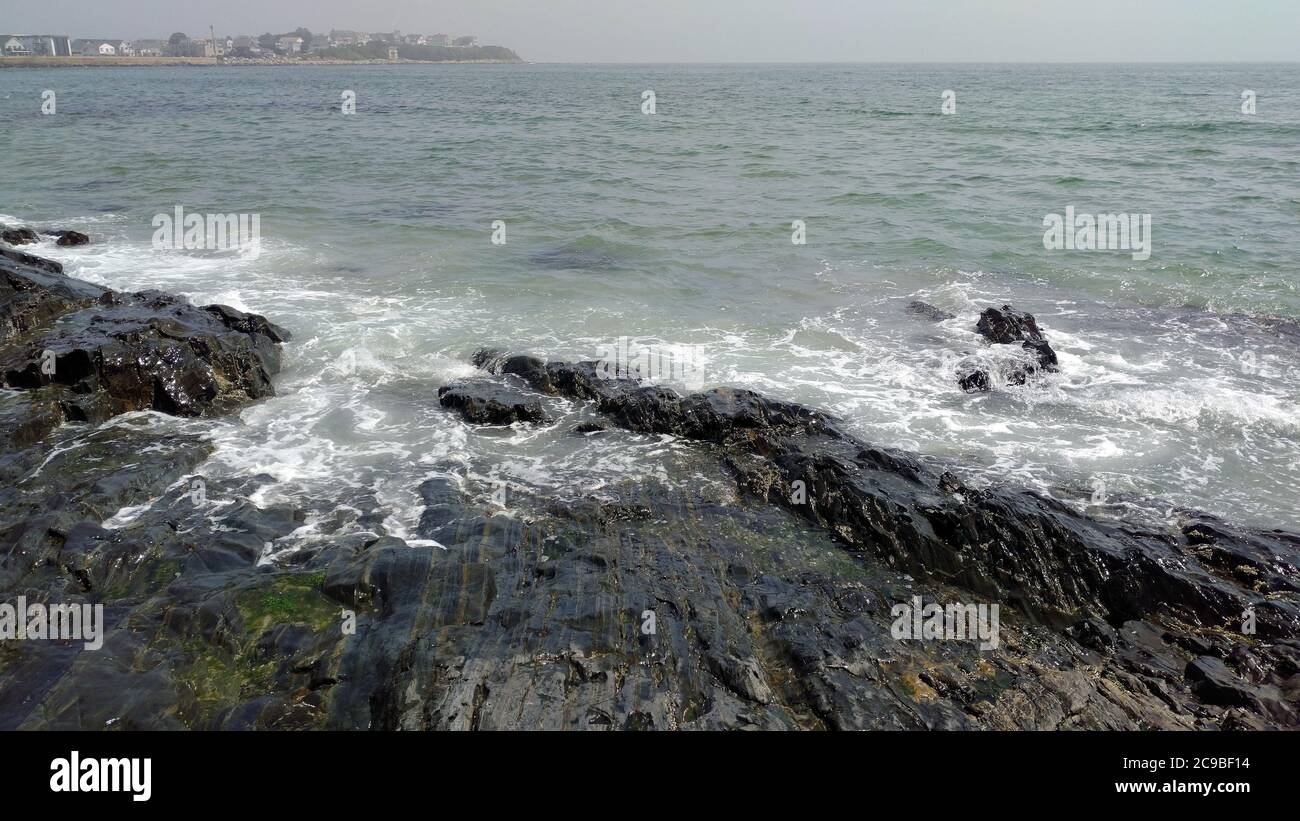 Surf waves running in the coastal rocks at the beach Stock Photo - Alamy