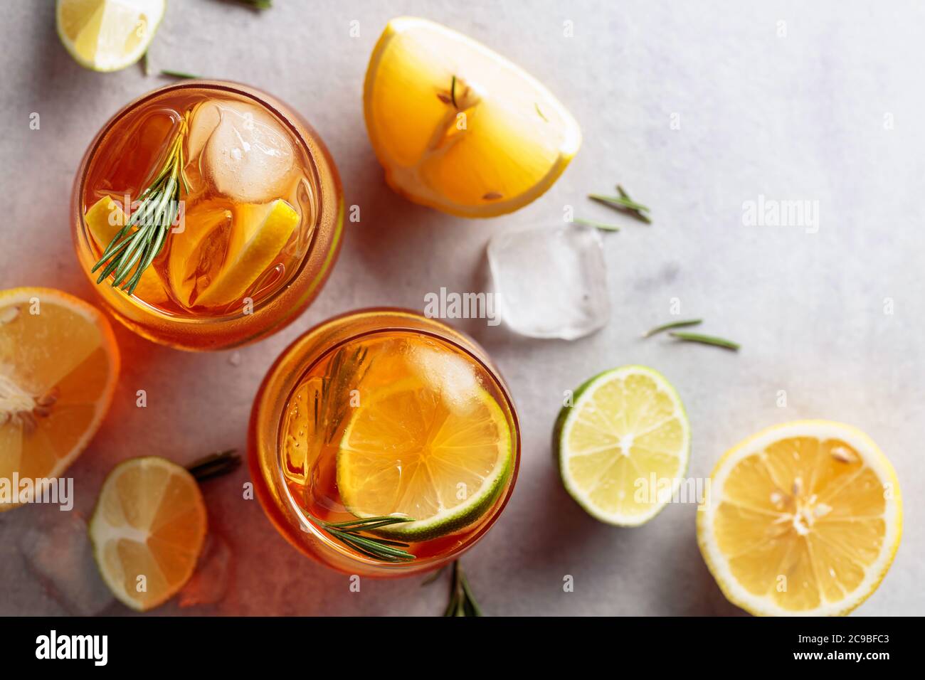 Traditional iced tea with lemon, lime and ice garnished with rosemary ...