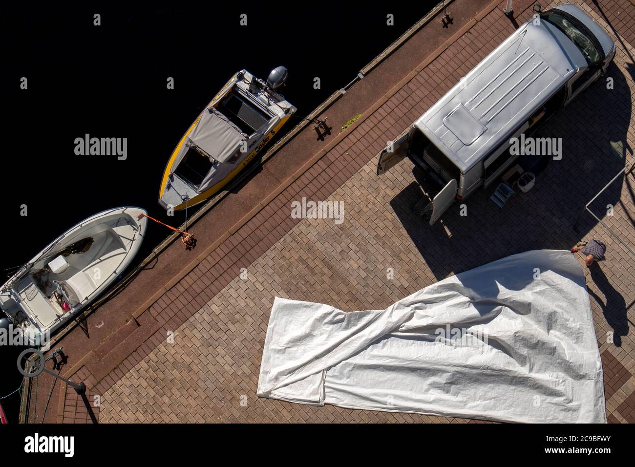 high angle view of a man folding tarp Stock Photo - Alamy