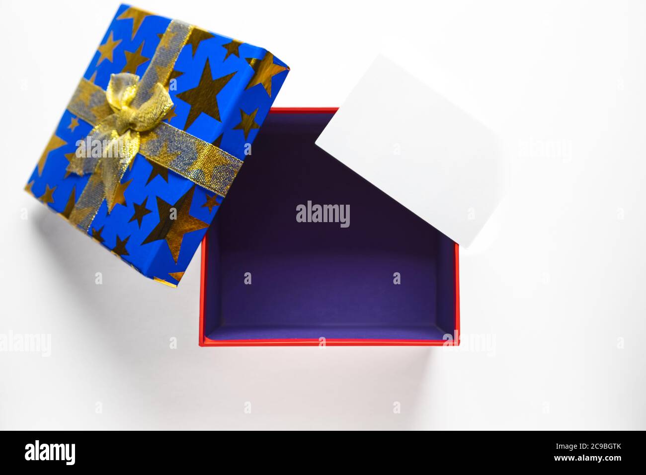 Gift or present empty box with golden ribbon and greeting card on white ...