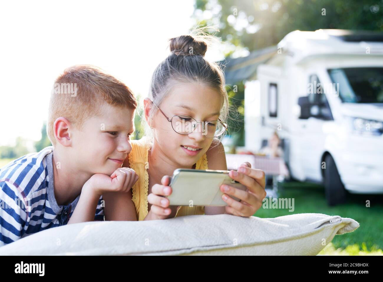 Children with mobile phone on camping holiday Stock Photo - Alamy