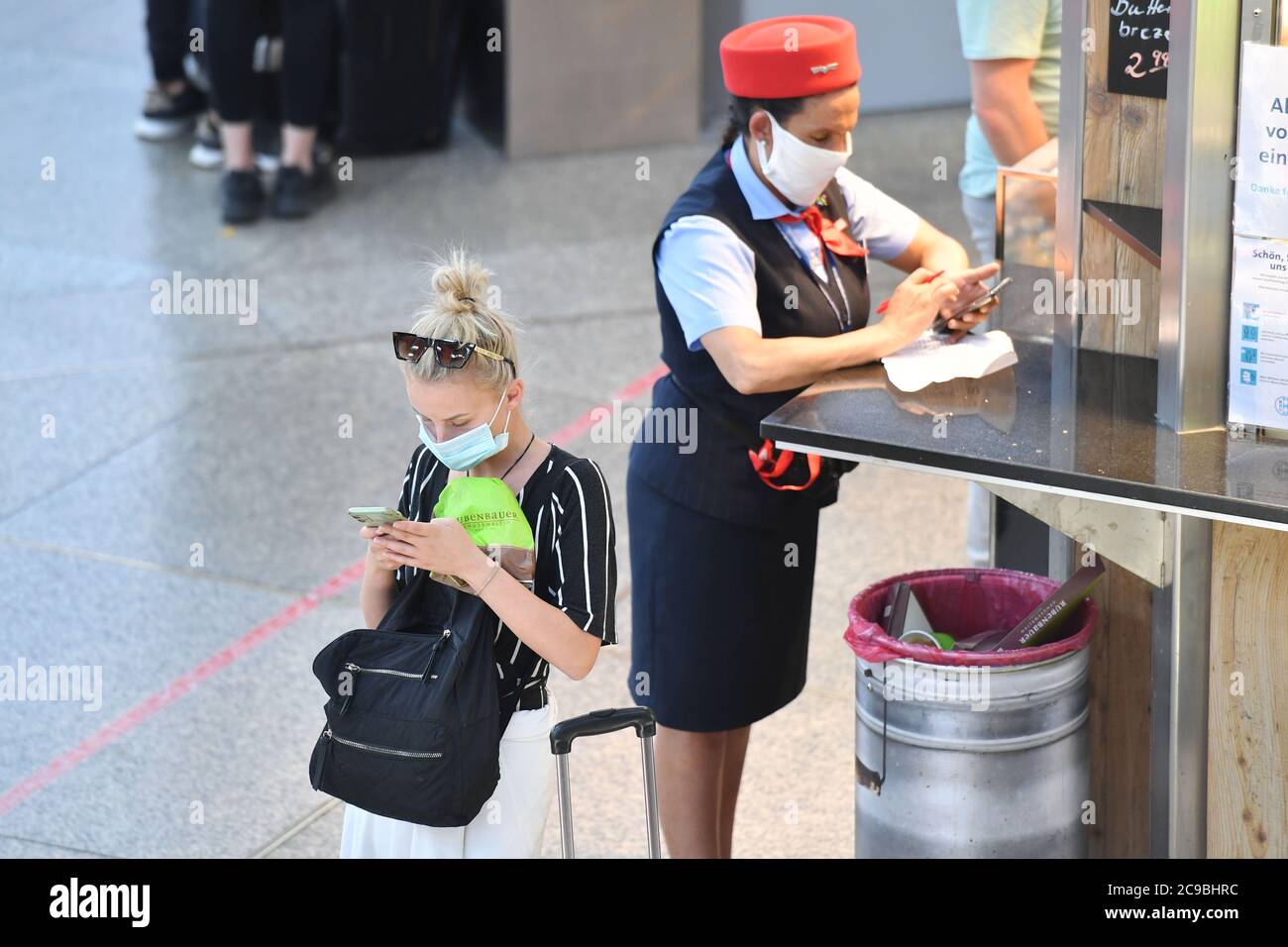 Passengers and employees of DB with cell phone, smartphone, face mask ...
