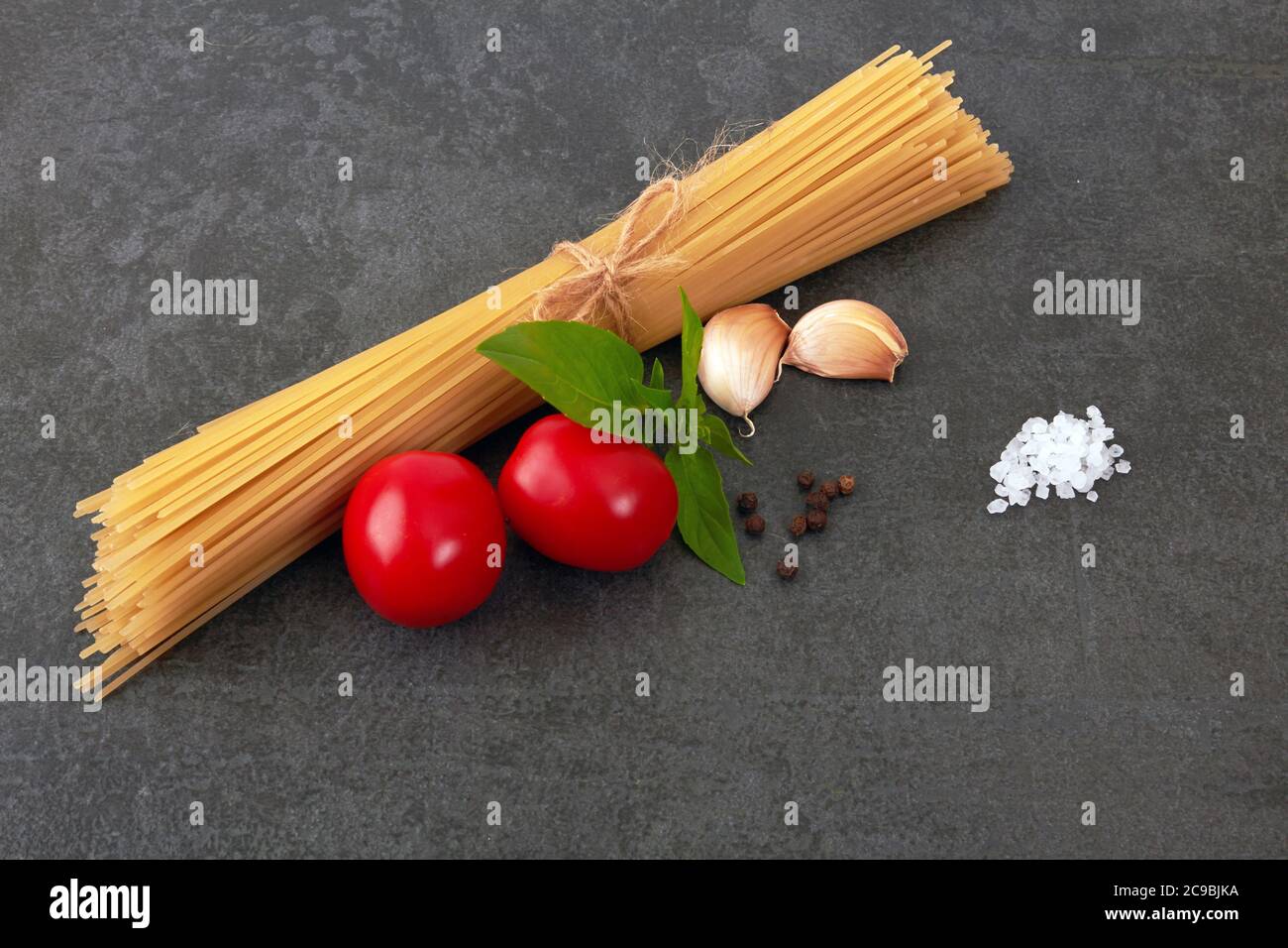 spaghetti on a stone black background with basil Stock Photo - Alamy