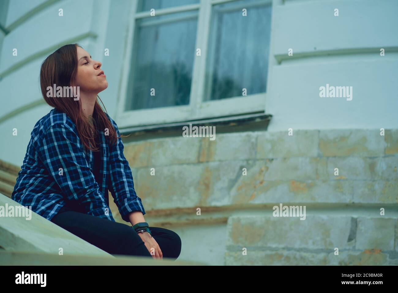 Young pretty woman poses on stairs of manor. Adult smiley female ...